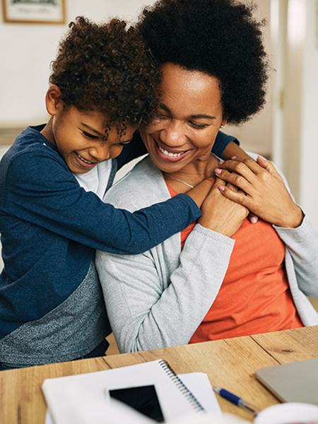 Happy African American mother and son embracing at home. | Executive ...